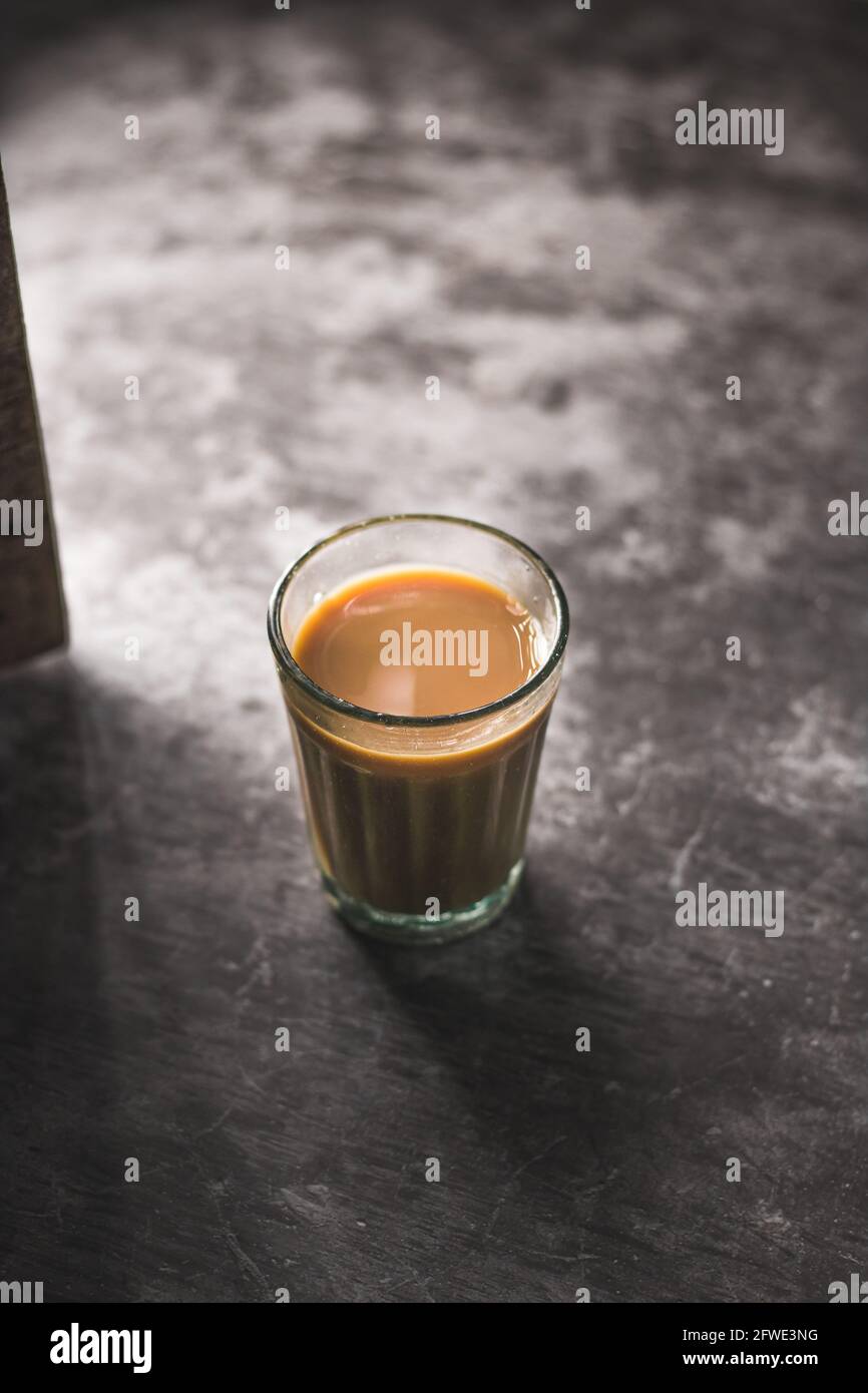 Indian chai in glass cups with metal kettle and other masalas to make ...