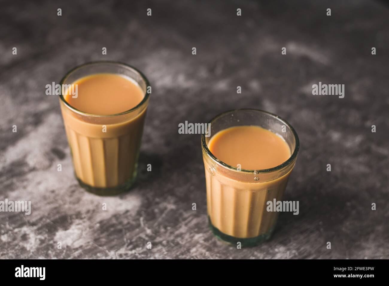 Indian chai in glass cups with metal kettle and other masalas to make ...