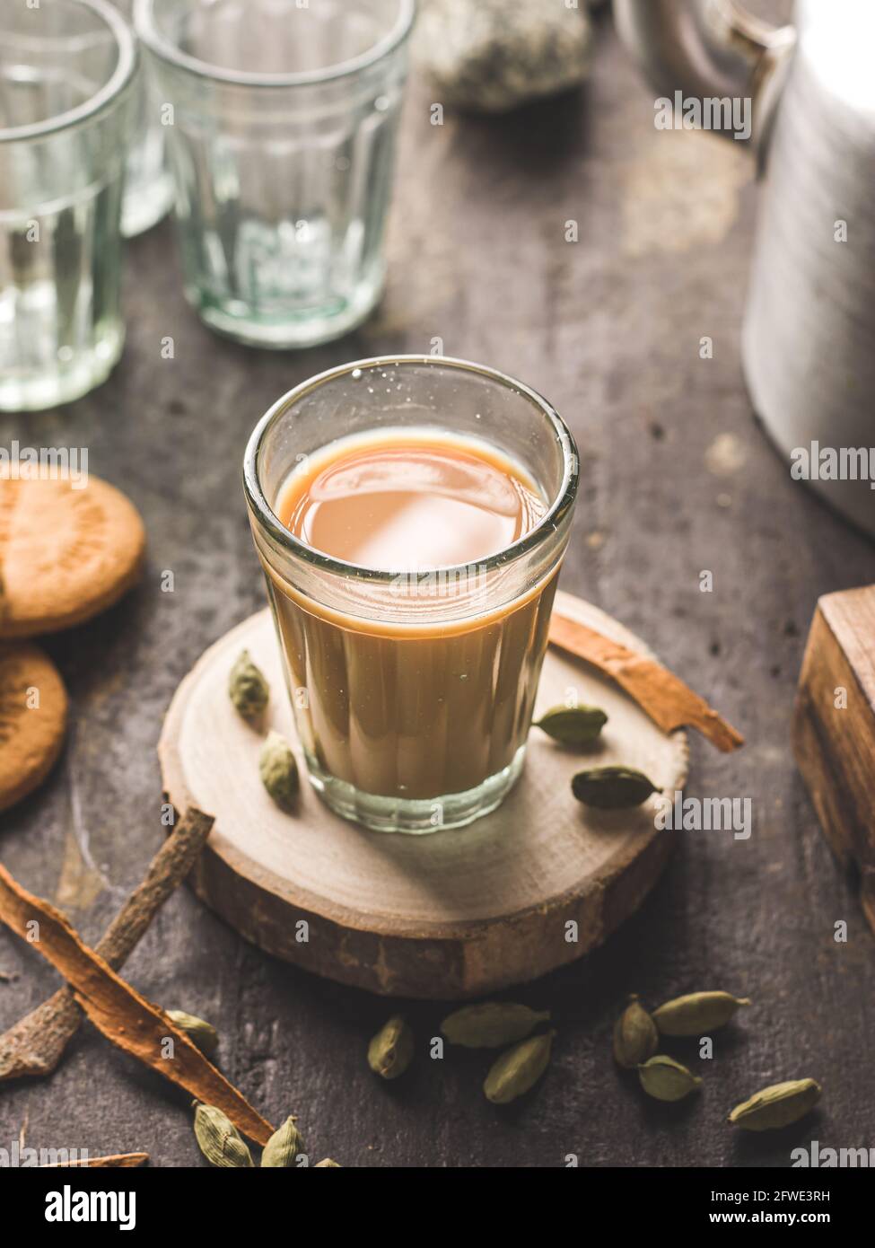 Indian chai in glass cups with metal kettle and other masalas to make ...