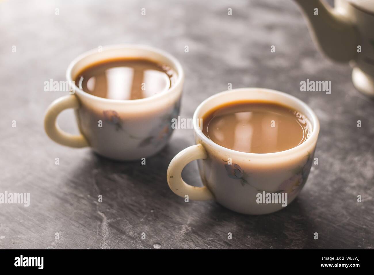 Indian chai in glass cups with metal kettle and other masalas to make ...