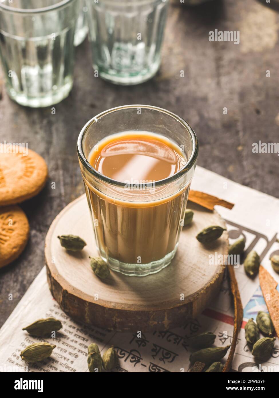 Indian chai in glass cups with metal kettle and other masalas to make ...