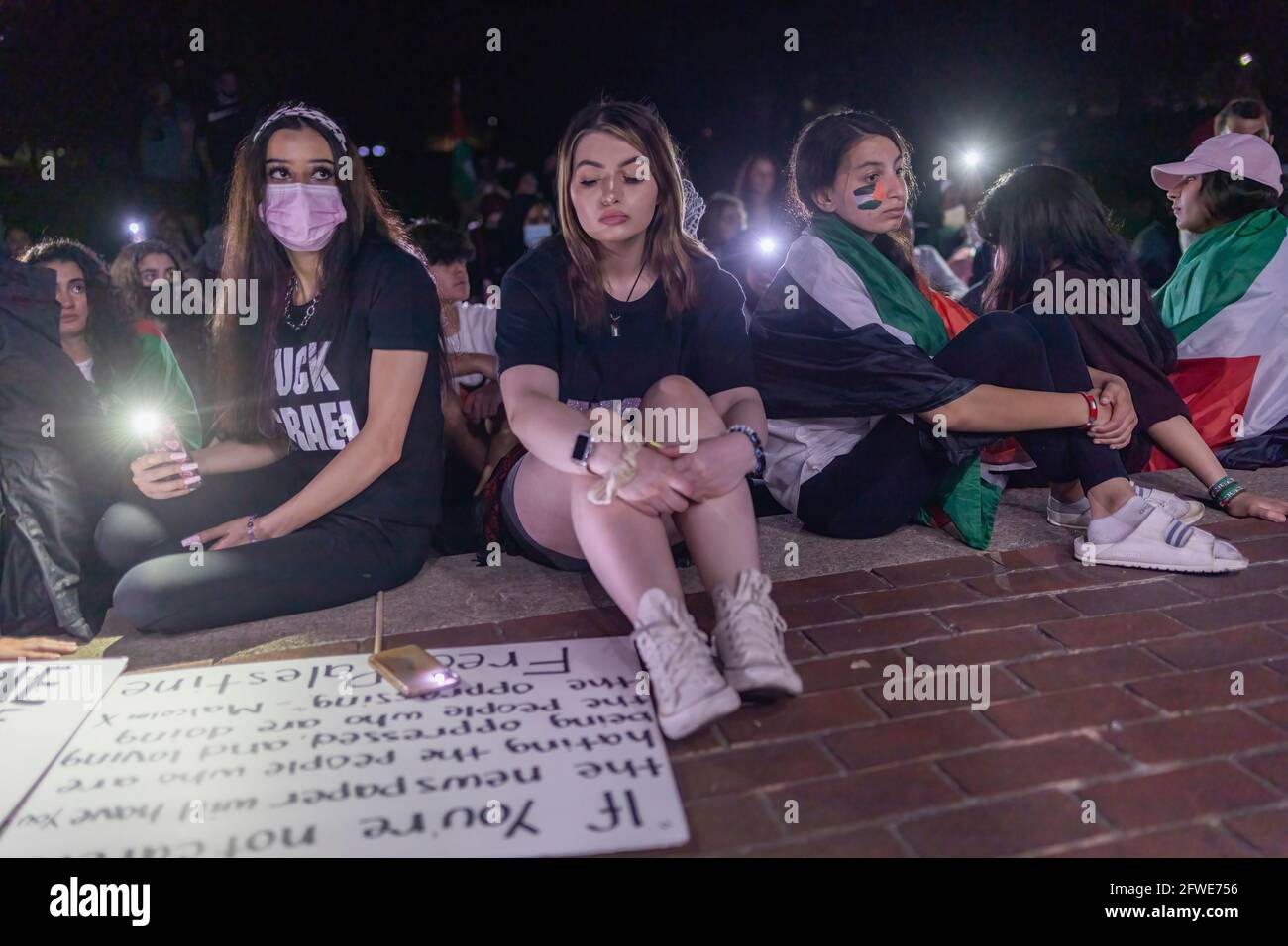 Female protesters observe a moment of silence during a candlelight ...