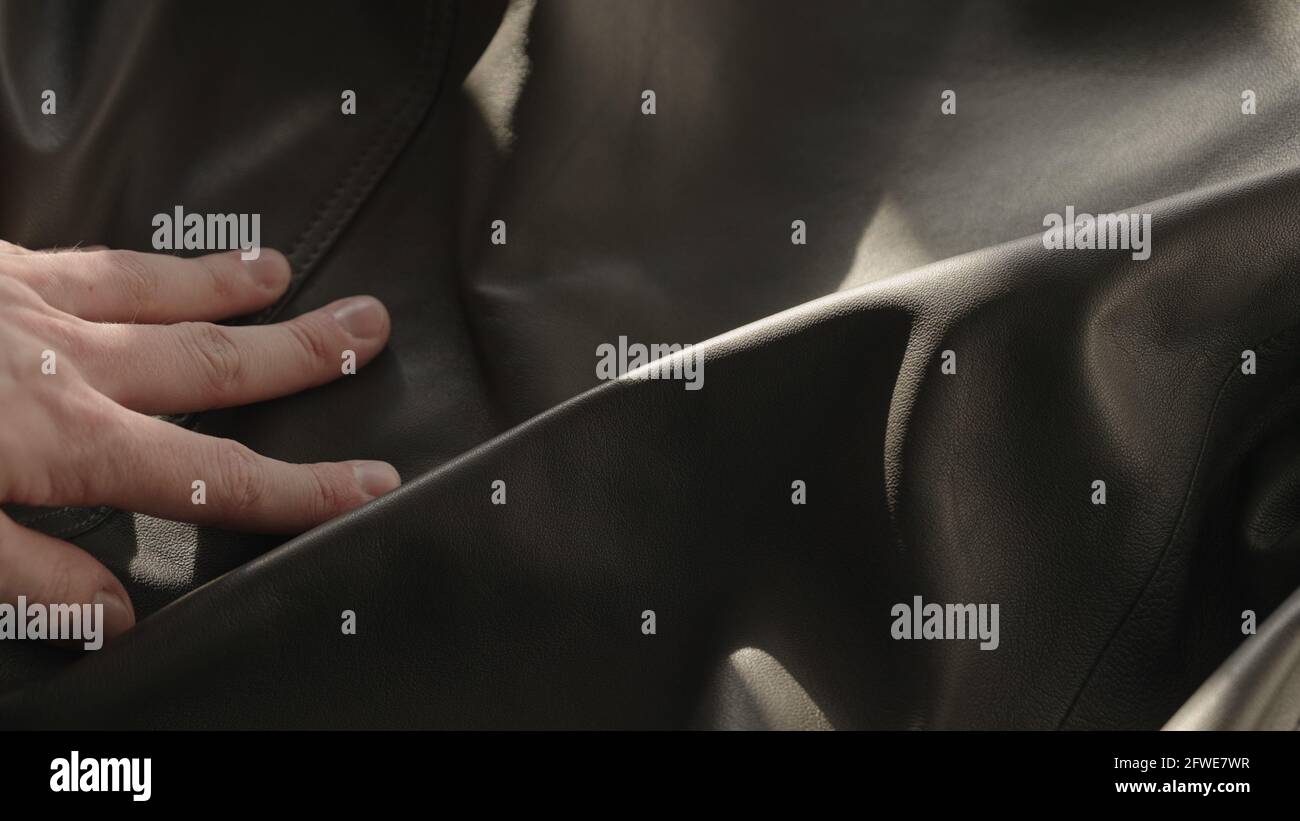 Man hand touching soft leather with sun shining from a window, wide ...