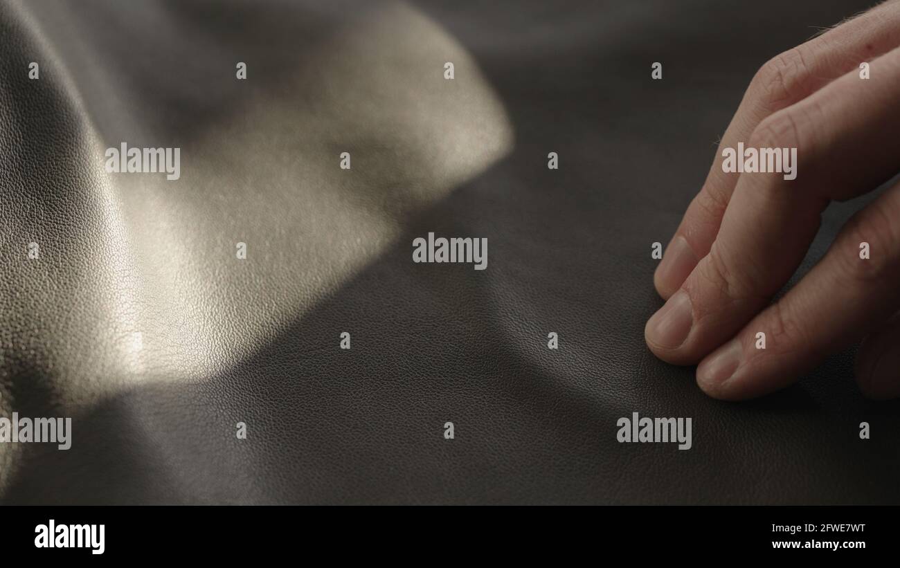 Man hand touching soft leather with sun shining from a window, wide ...