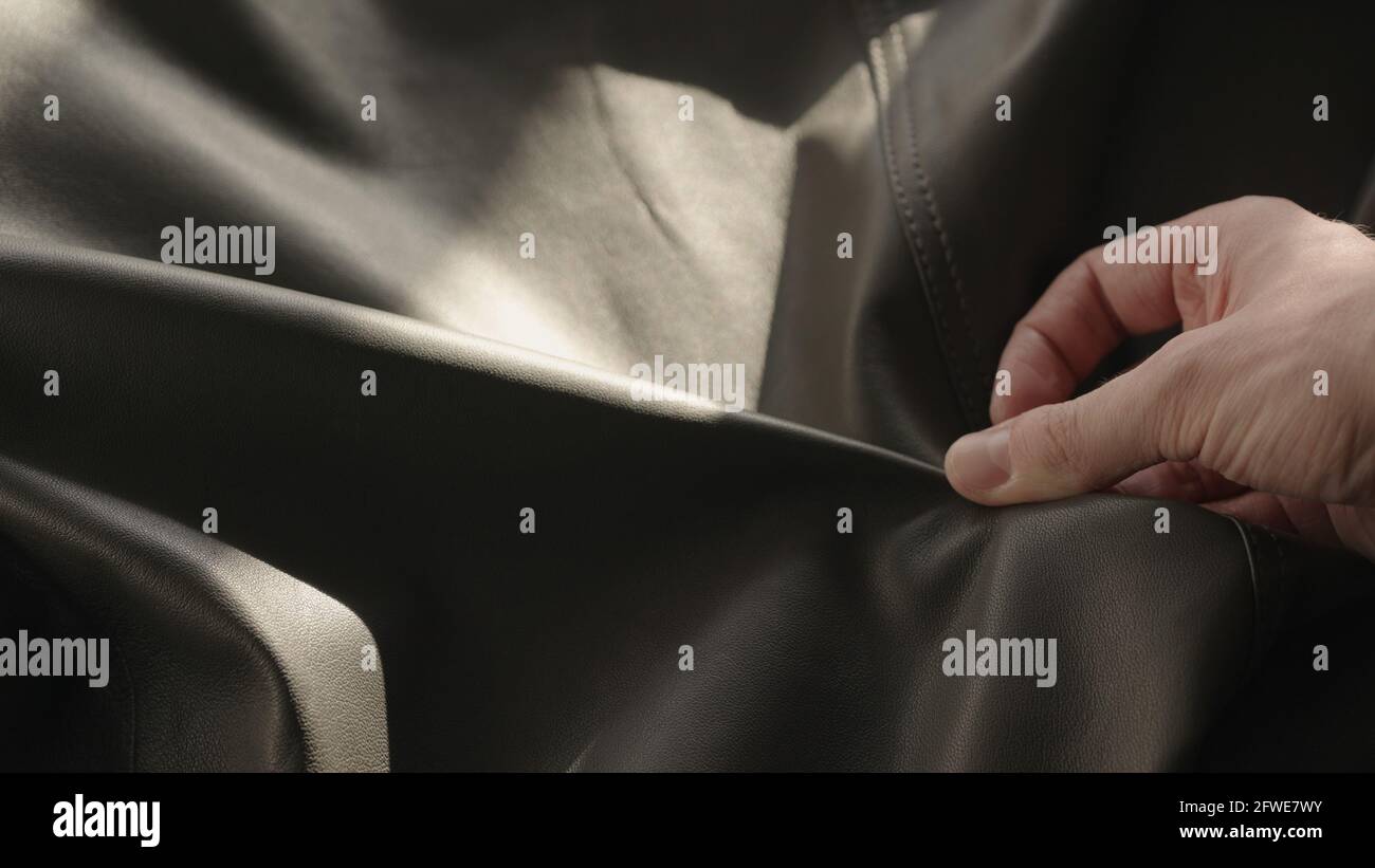 Man hand touching soft leather with sun shining from a window, wide ...