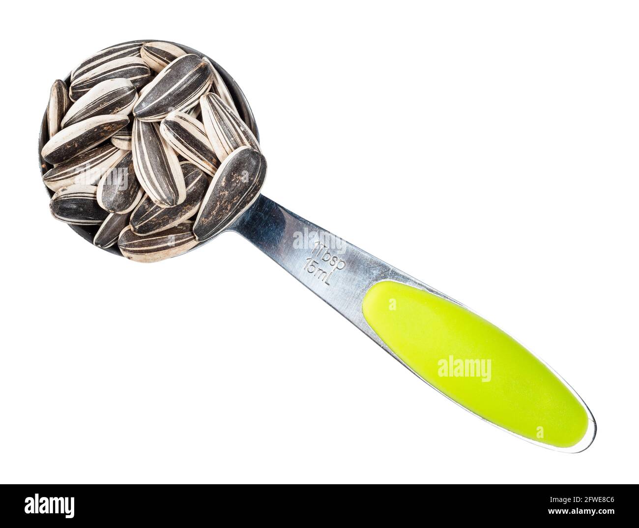 top view of whole sunflower seeds in measuring spoon cutout on white ...