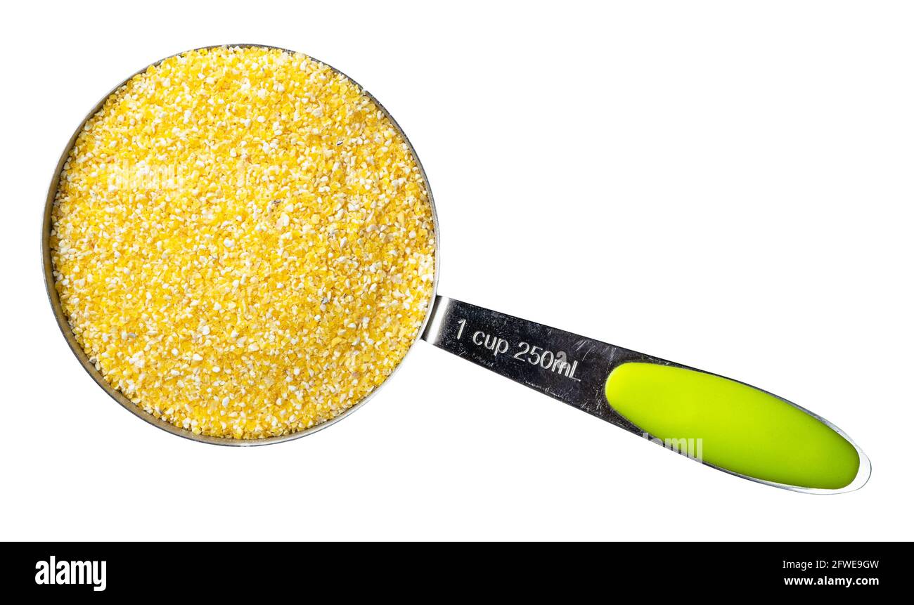 top view of coarse ground cornmeal in measuring cup cutout on white ...