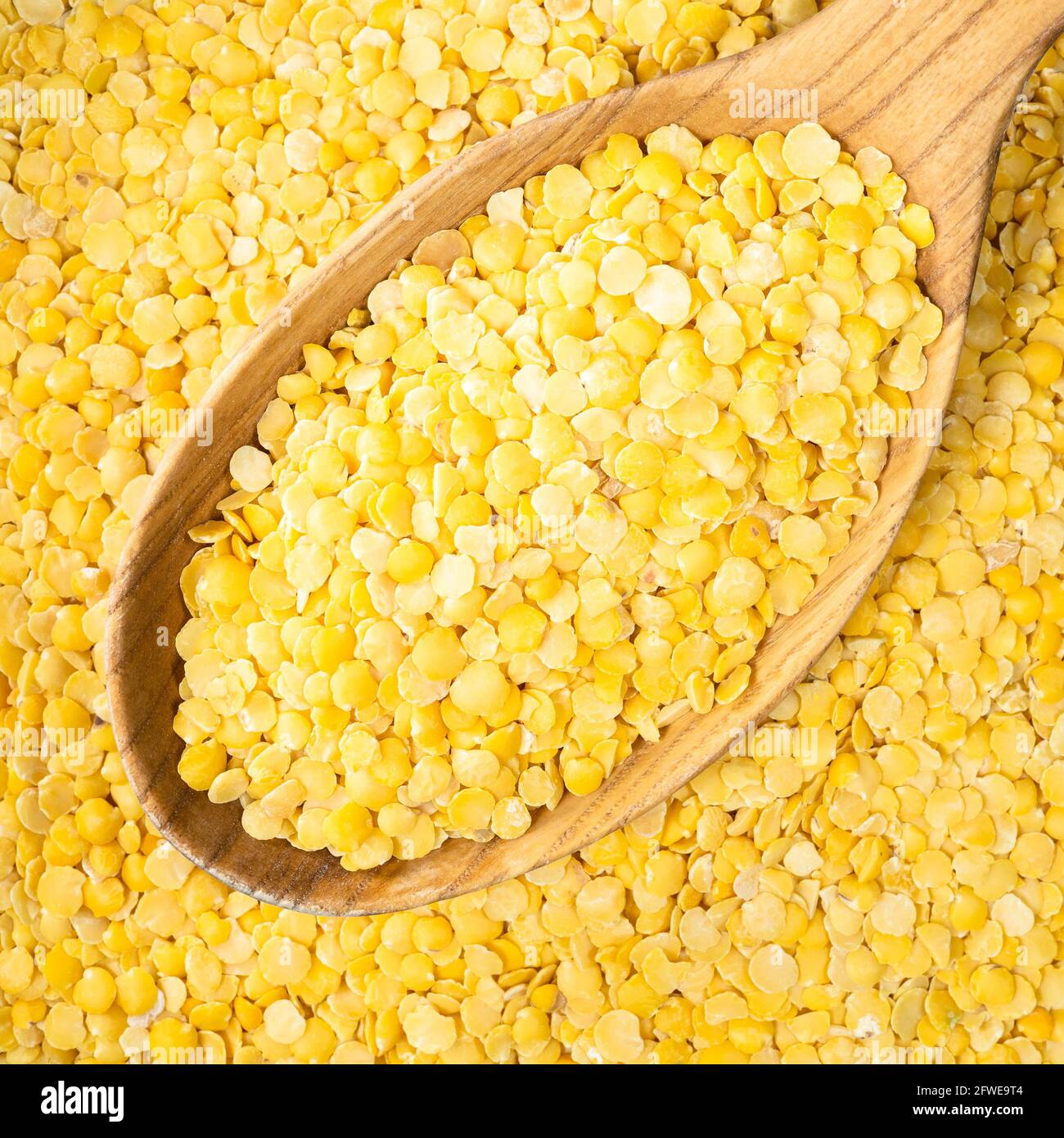 top view of split yellow lentils in wooden spoon closeup Stock Photo ...