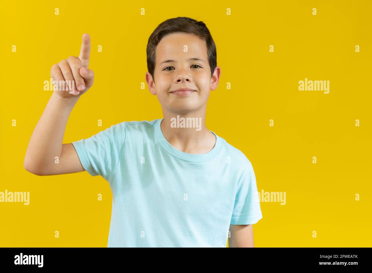 Photo of young Boy funny holding up index finger pointing up at ...