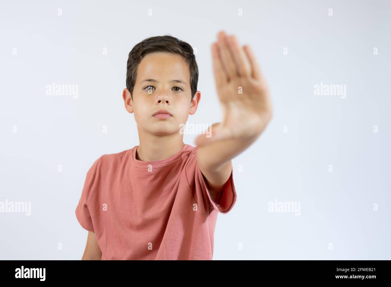 portrait of young boy doing stop symbol over white background Stock ...