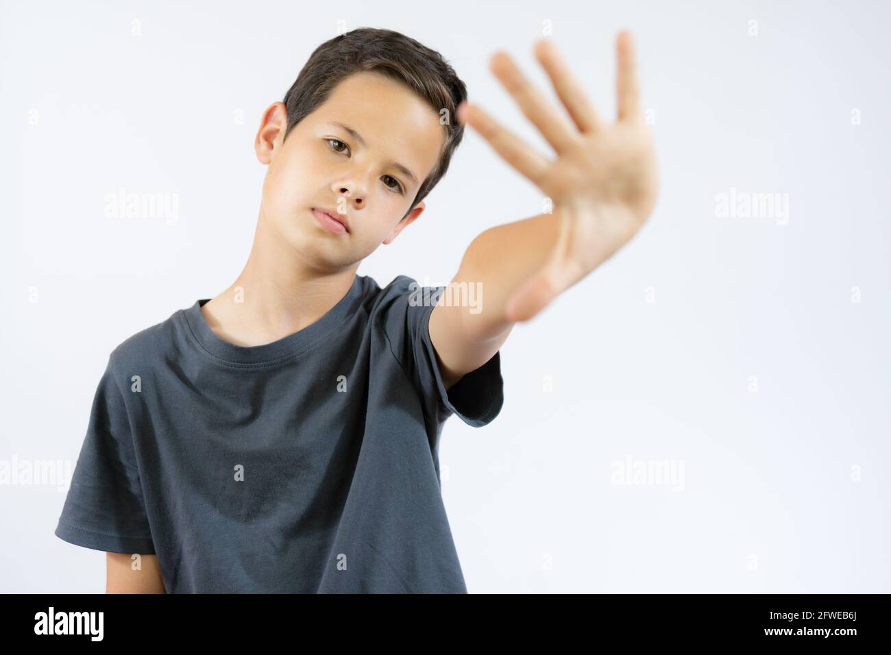 portrait of young boy doing stop symbol over white background Stock ...
