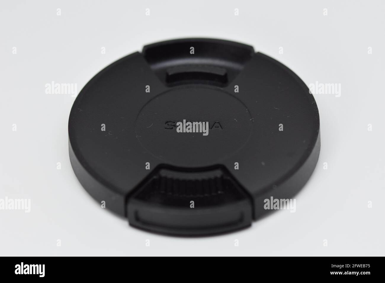 A black Sigma macro lens cap/cover with a clean white background Stock ...