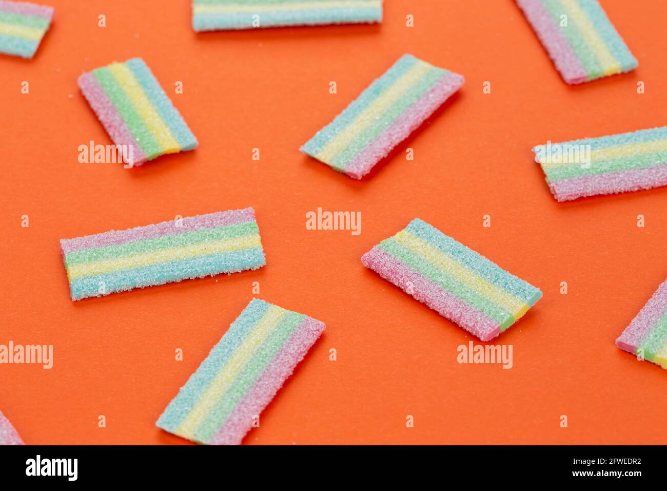 Colorful gummy candy pattern on an orange background. Soft gums look ...