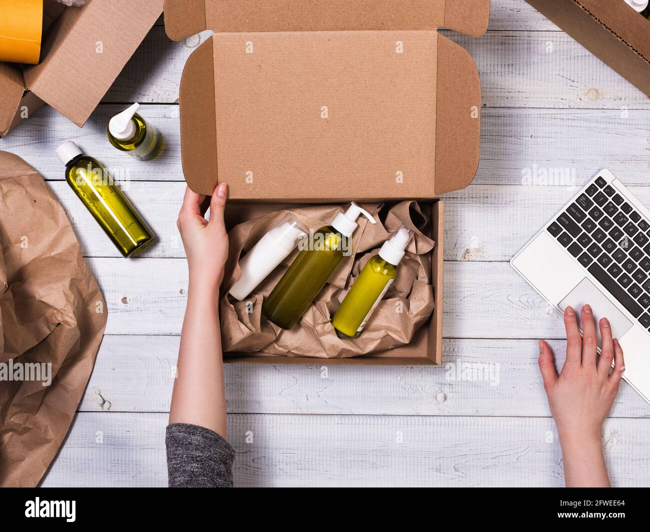 The female warehouse worker packs up cosmetics in a cardboard box for ...