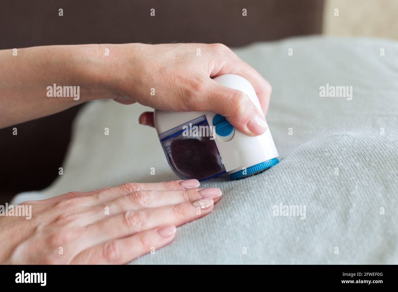 Removal of wool pellets by the device on everyday clothes close-up ...