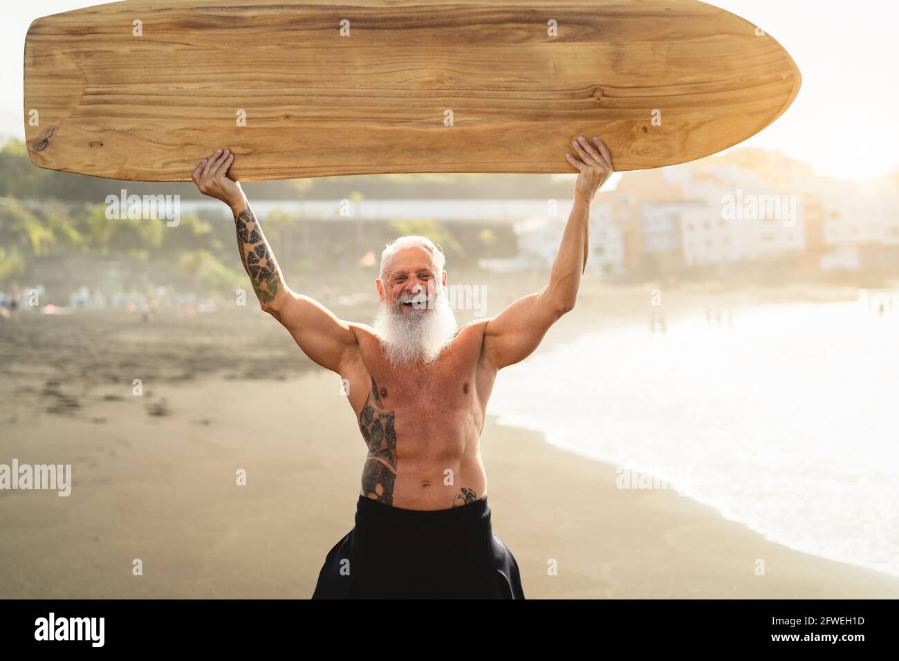 Senior male having fun surfing during sunset time - Fit retired man ...