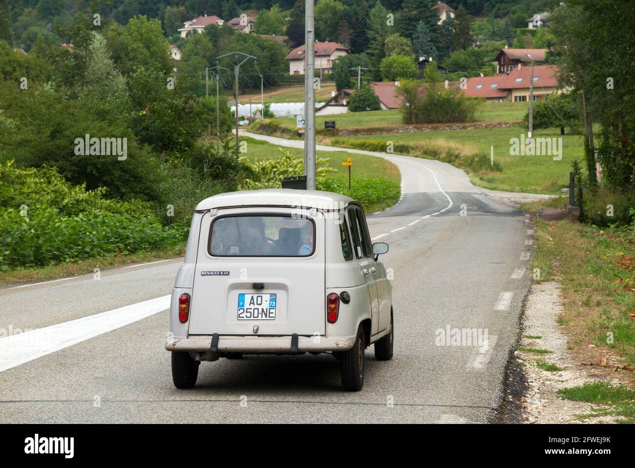 Renault 4 L car driver driving on a road near in Haute Savoie in France ...