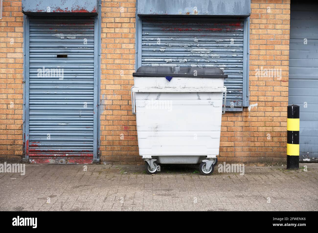 Wheelie bin skip for refuge collection in row Stock Photo - Alamy