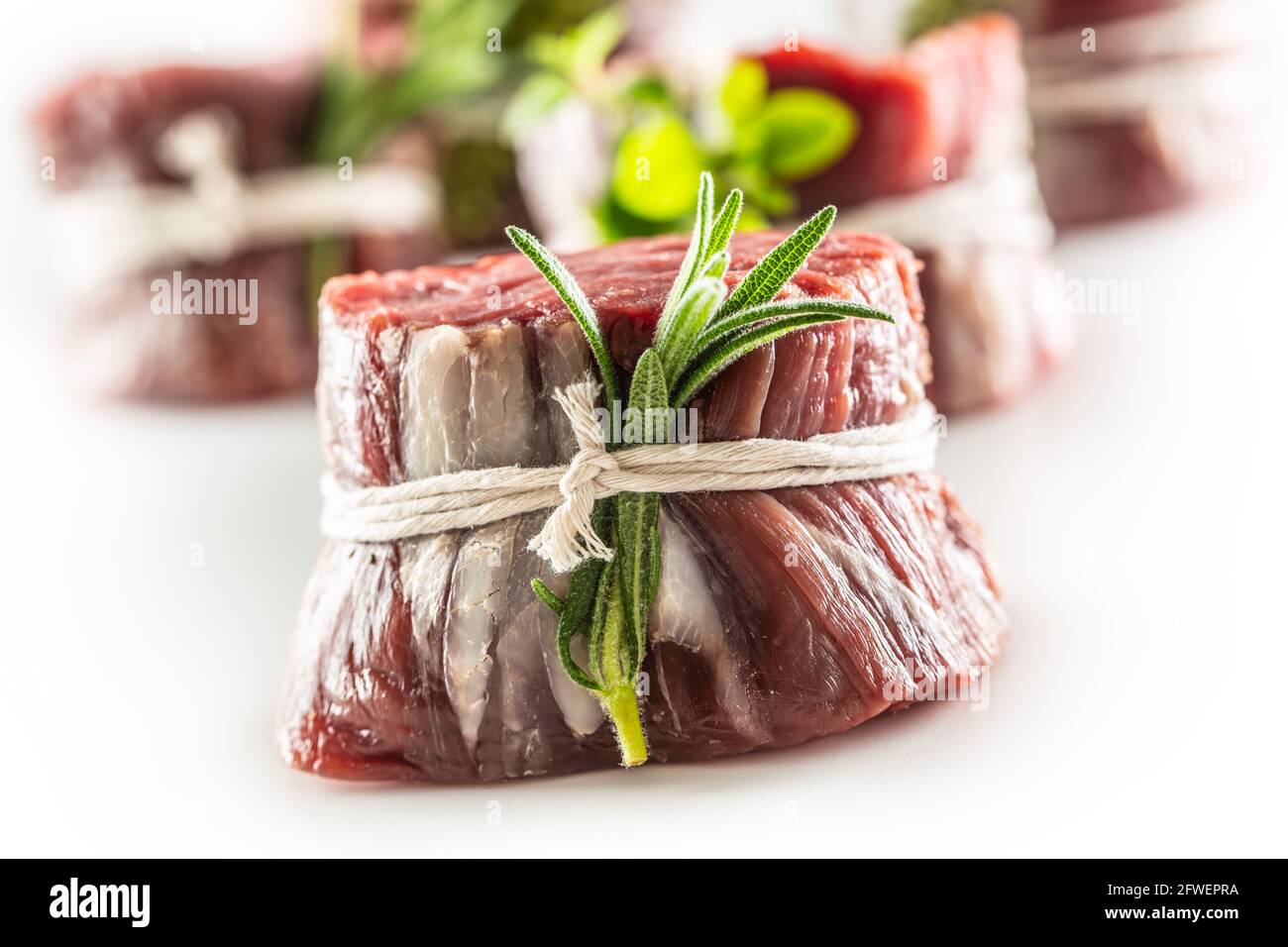 Raw steak cut with rosemary wrapped by a string Stock Photo - Alamy