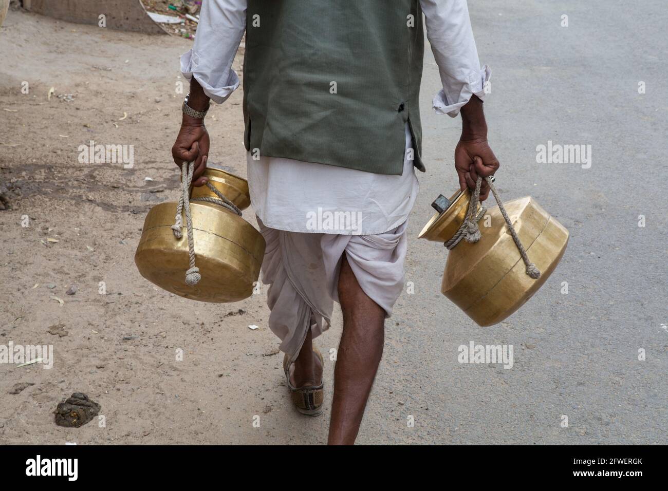 A man carrying water pots in Pushkar, Rajasthan, India Stock Photo - Alamy
