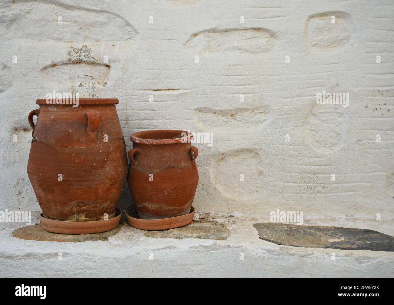 Traditional handmade clay urns against a whitewashed textured wall in ...