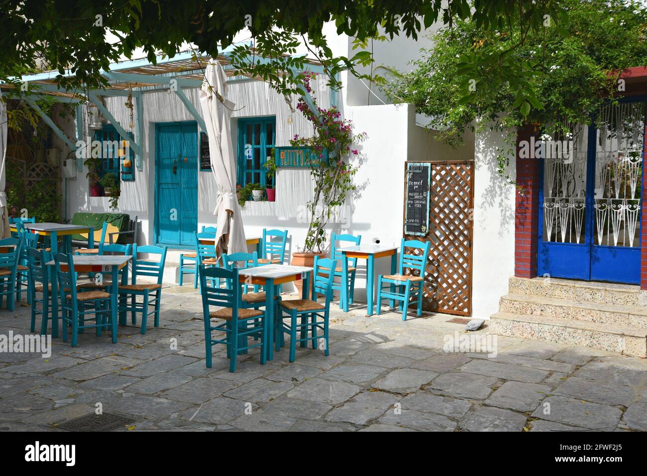 Traditional Greek taverna picturesque patio with turquoise furniture in ...