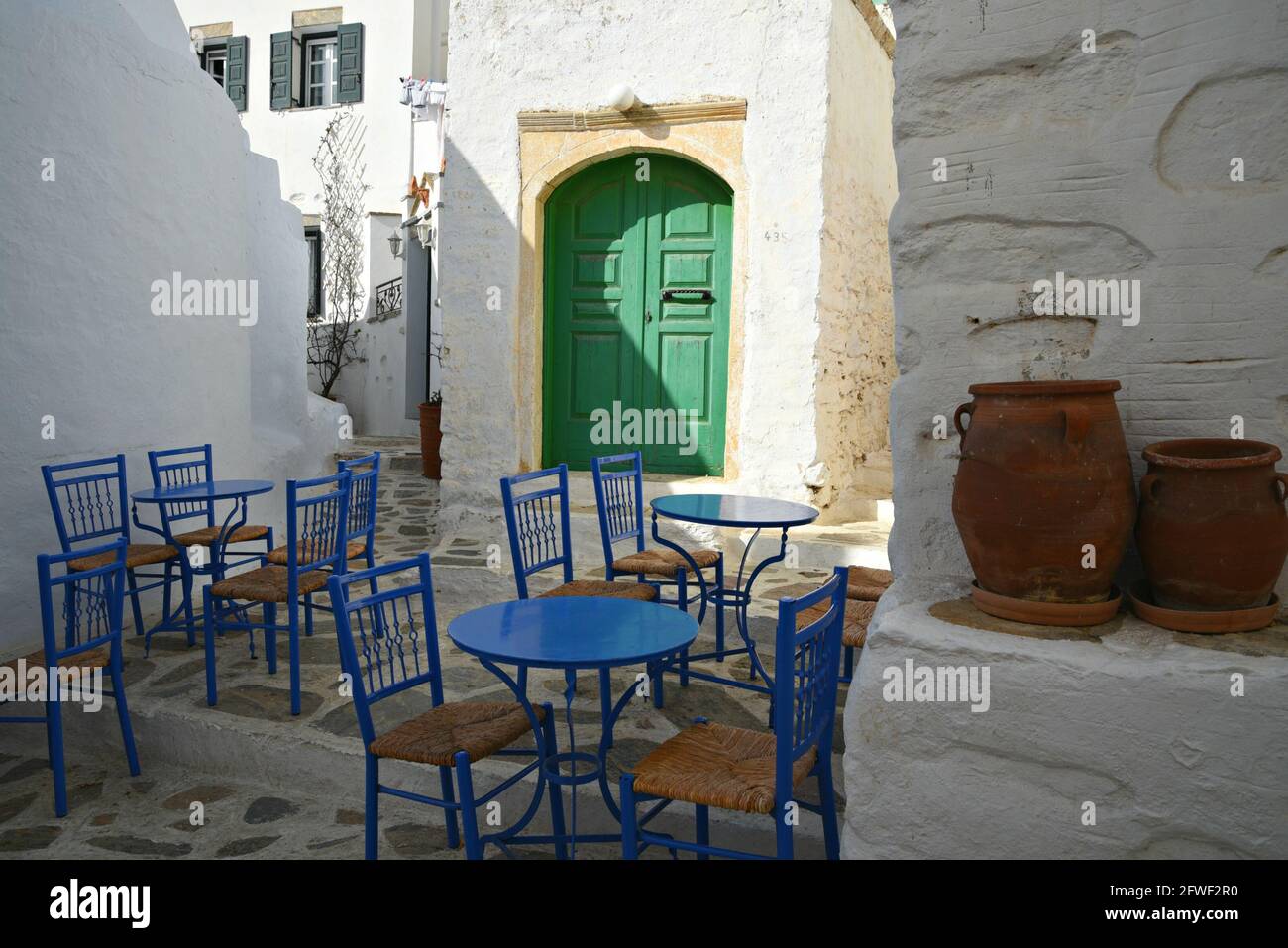 Traditional Greek taverna picturesque patio with blue bistro tables and ...