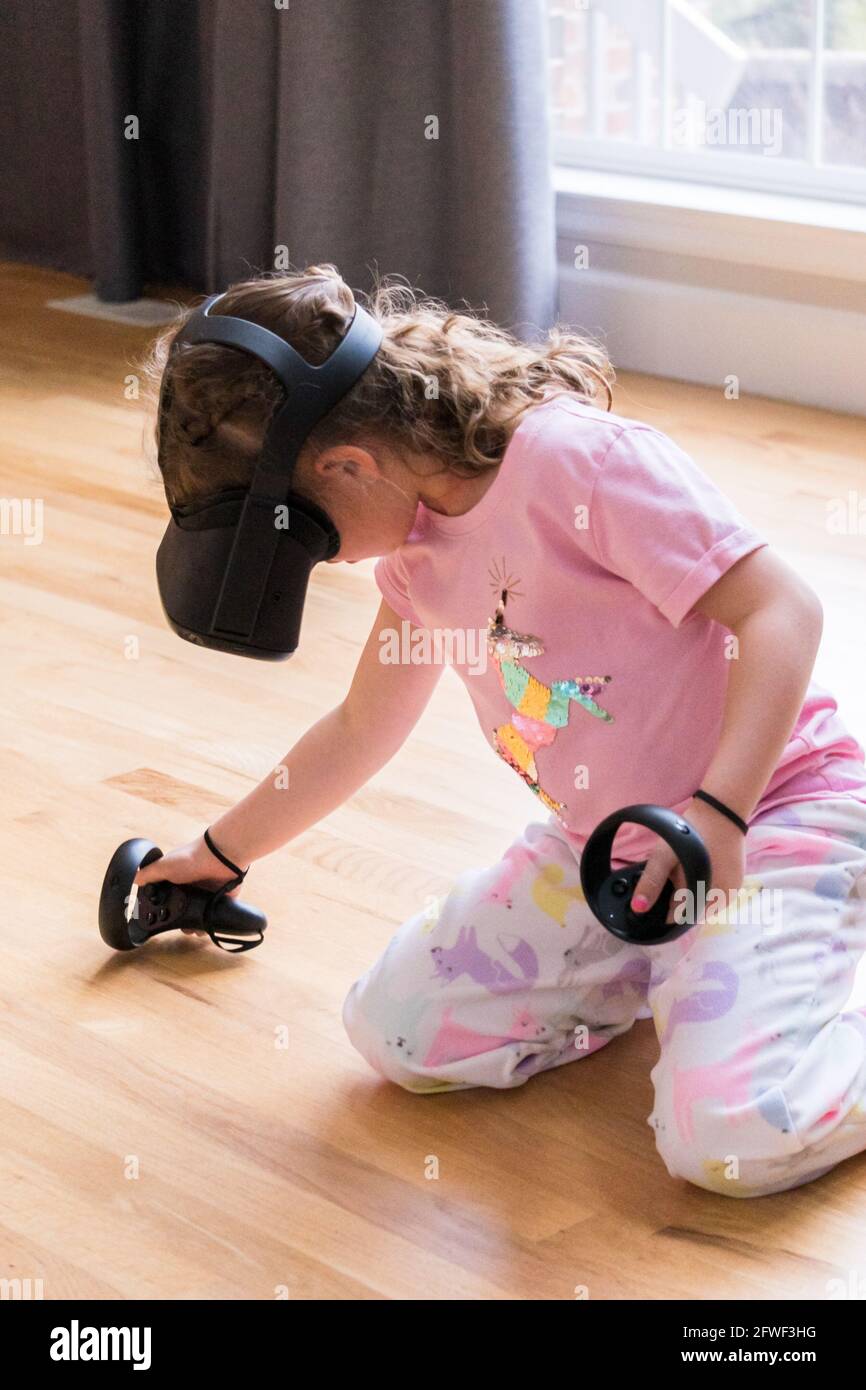 Little girl playing virtual reality game in the living room Stock Photo ...