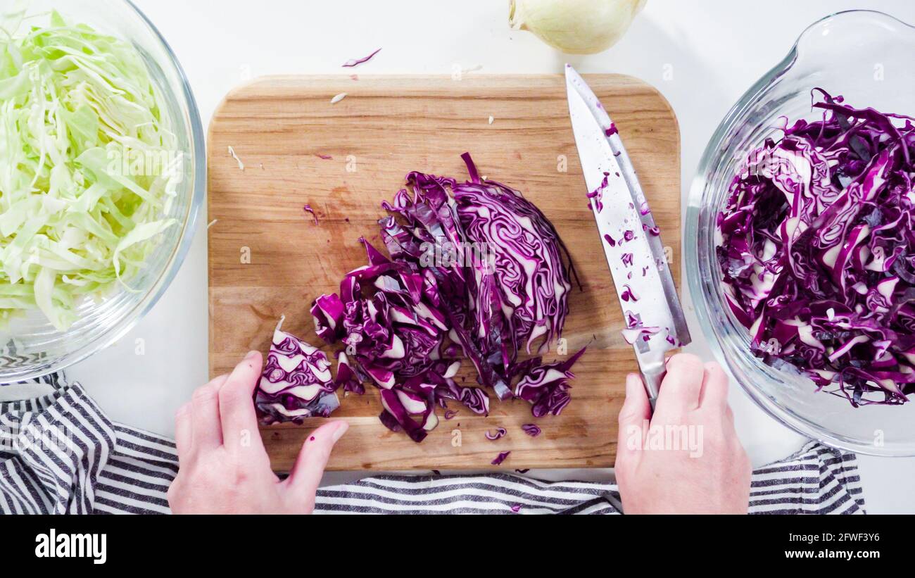 Flat lay. Step by step. Shredding organic cabbage on a wood cutting ...