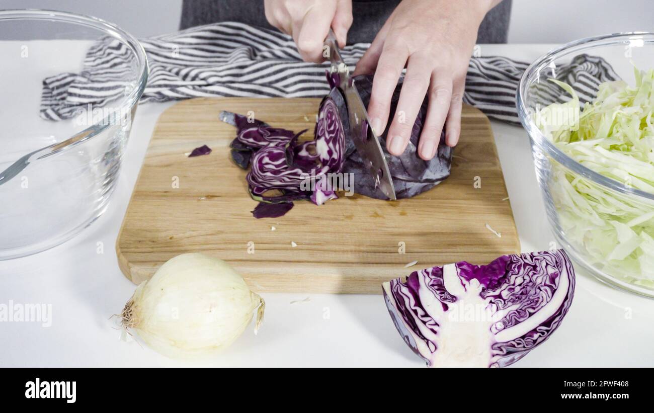 Step by step. Shredding organic cabbage on a wood cutting board Stock ...