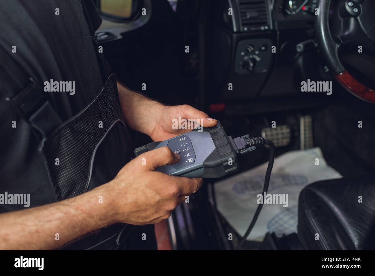 Mid section of mechanic holding a diagnostic tool Stock Photo - Alamy