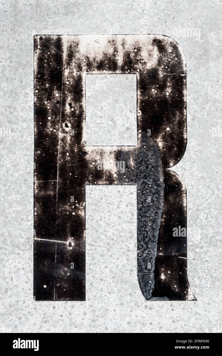 Weathered black letter R of a signpost Stock Photo - Alamy