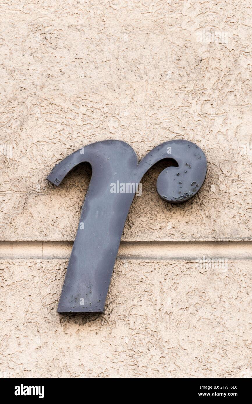 Grey metal letter r on a sand-coloured house wall Stock Photo - Alamy