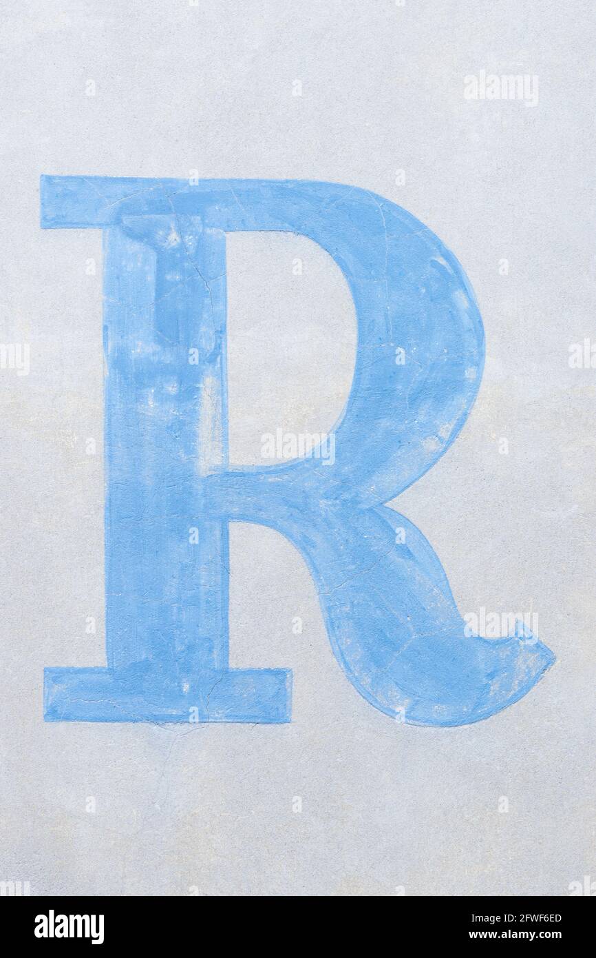 Light blue letter R in serif font on a light grey wall Stock Photo - Alamy