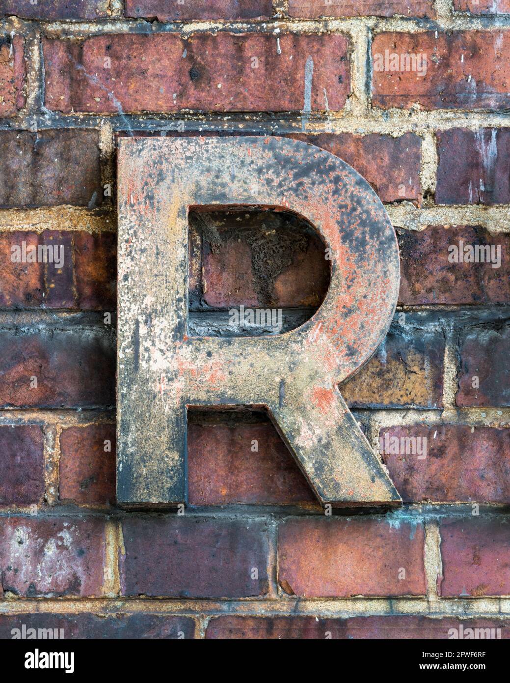 Weathered metal letter R in front of a brick wall Stock Photo - Alamy
