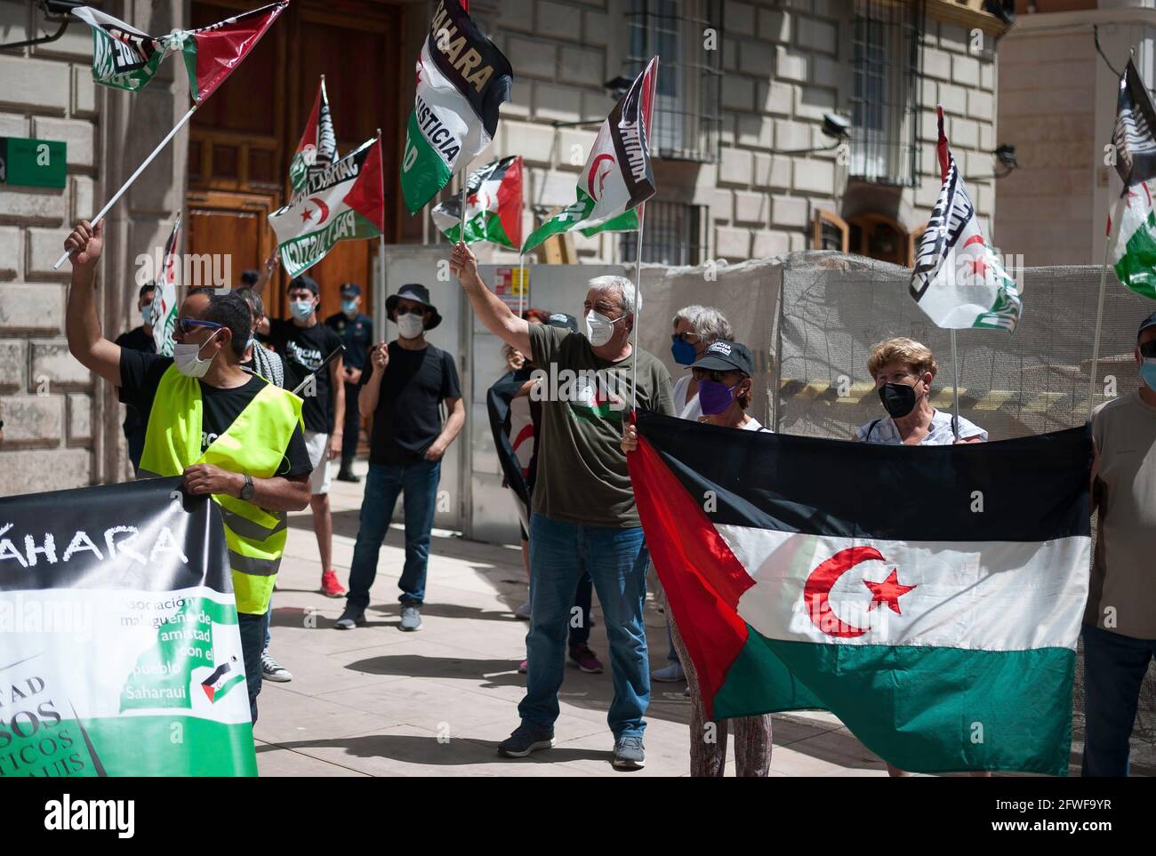 Protesters wearing face masks hold flags and banners as they take part ...