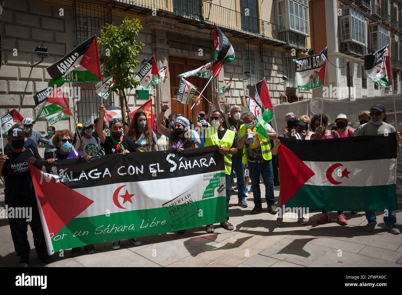 Protesters wearing face masks hold flags and banners as they take part ...