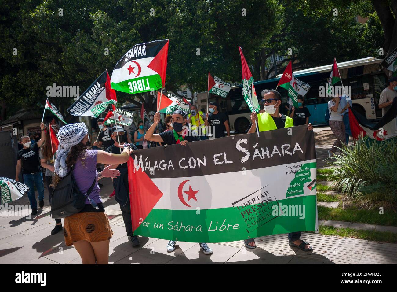 Protesters wearing face masks hold flags and banners as they take part ...