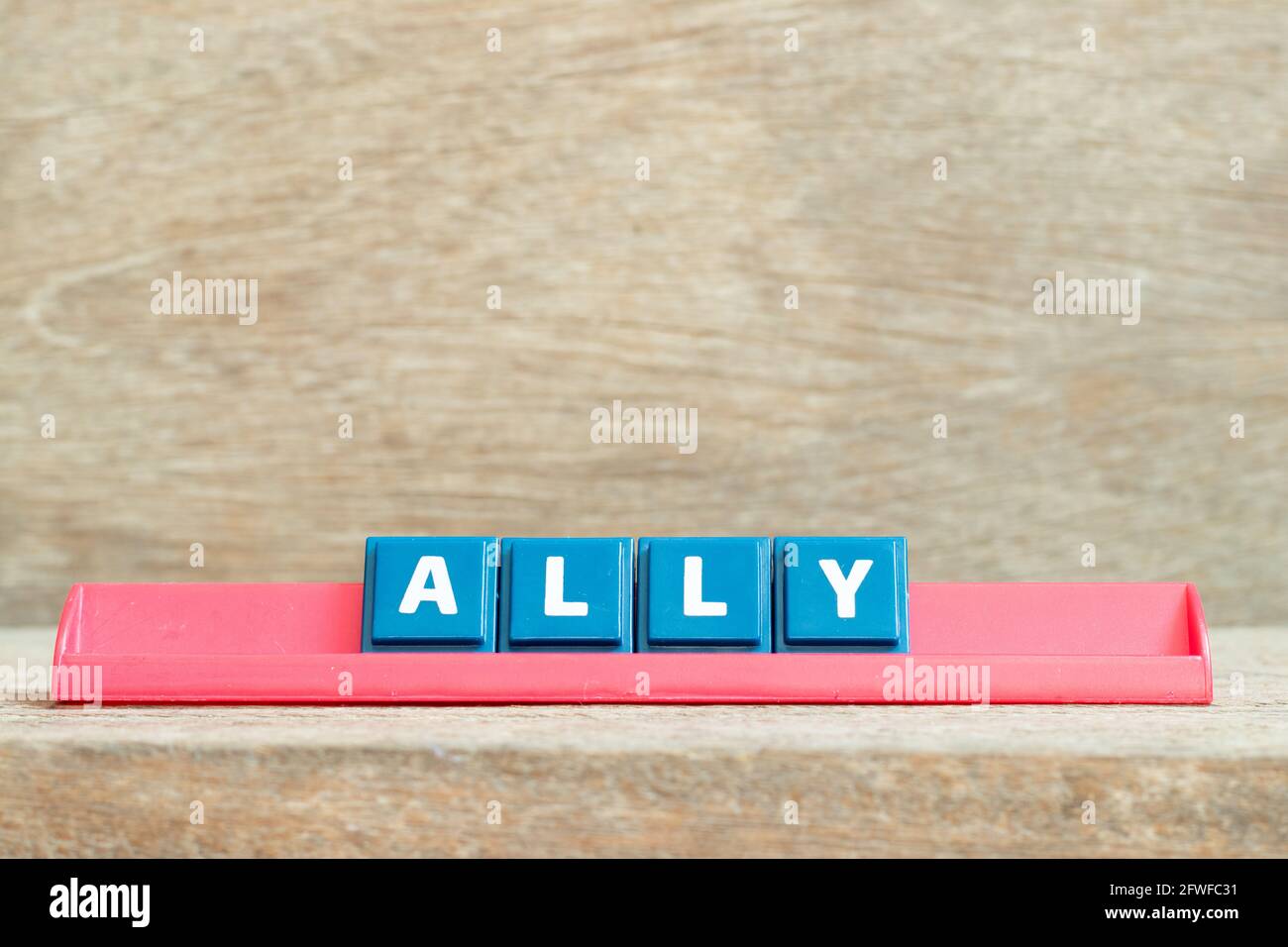 Tile alphabet letter with word ally in red color rack on wood ...