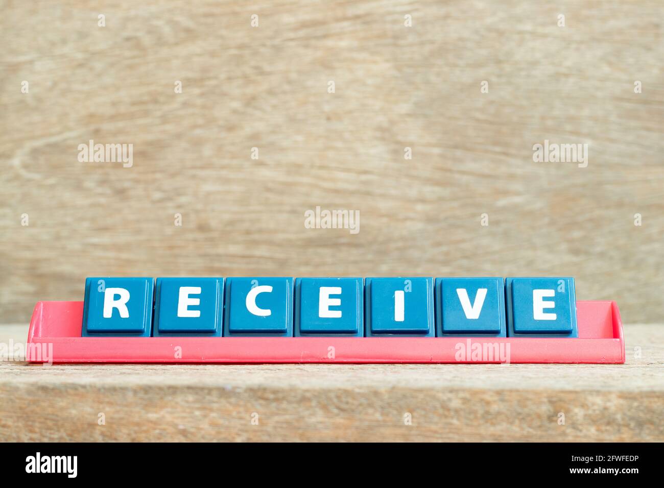 Tile alphabet letter with word receive in red color rack on wood ...