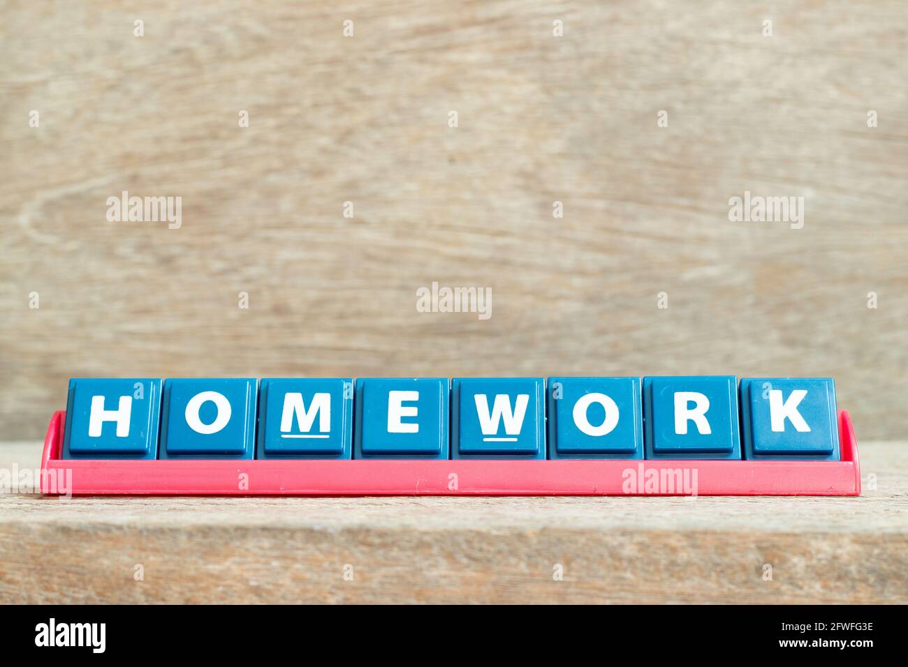 Tile alphabet letter with word homework in red color rack on wood ...