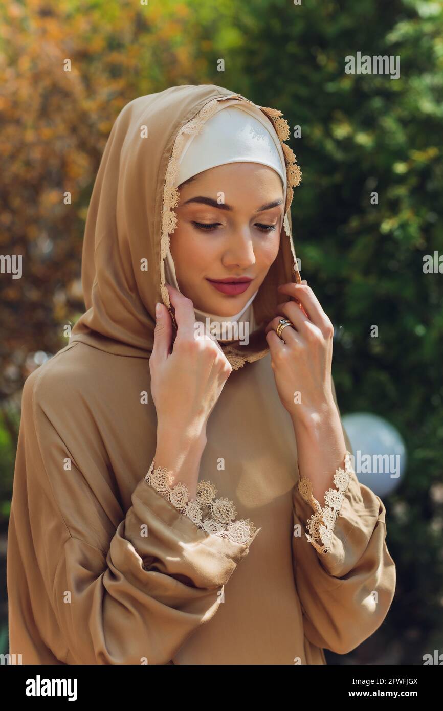 Islamic beautiful woman in a Muslim dress standing on a summer park ...