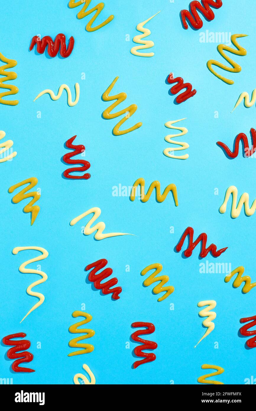 Ketchup mayonnaise and mustard sauce swirl pattern on light blue ...