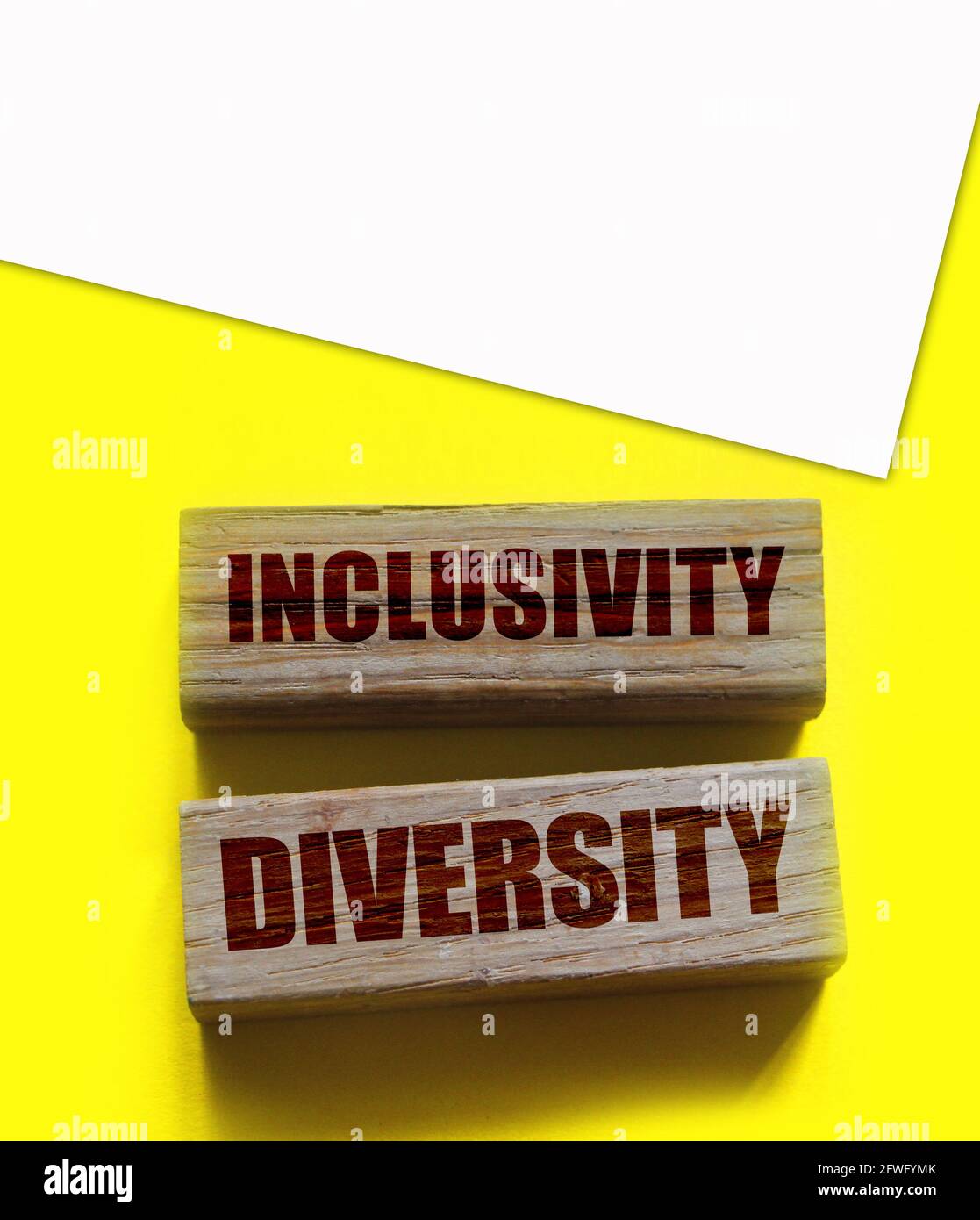 Inclusivity diversity words on wooden block on the yellow background ...