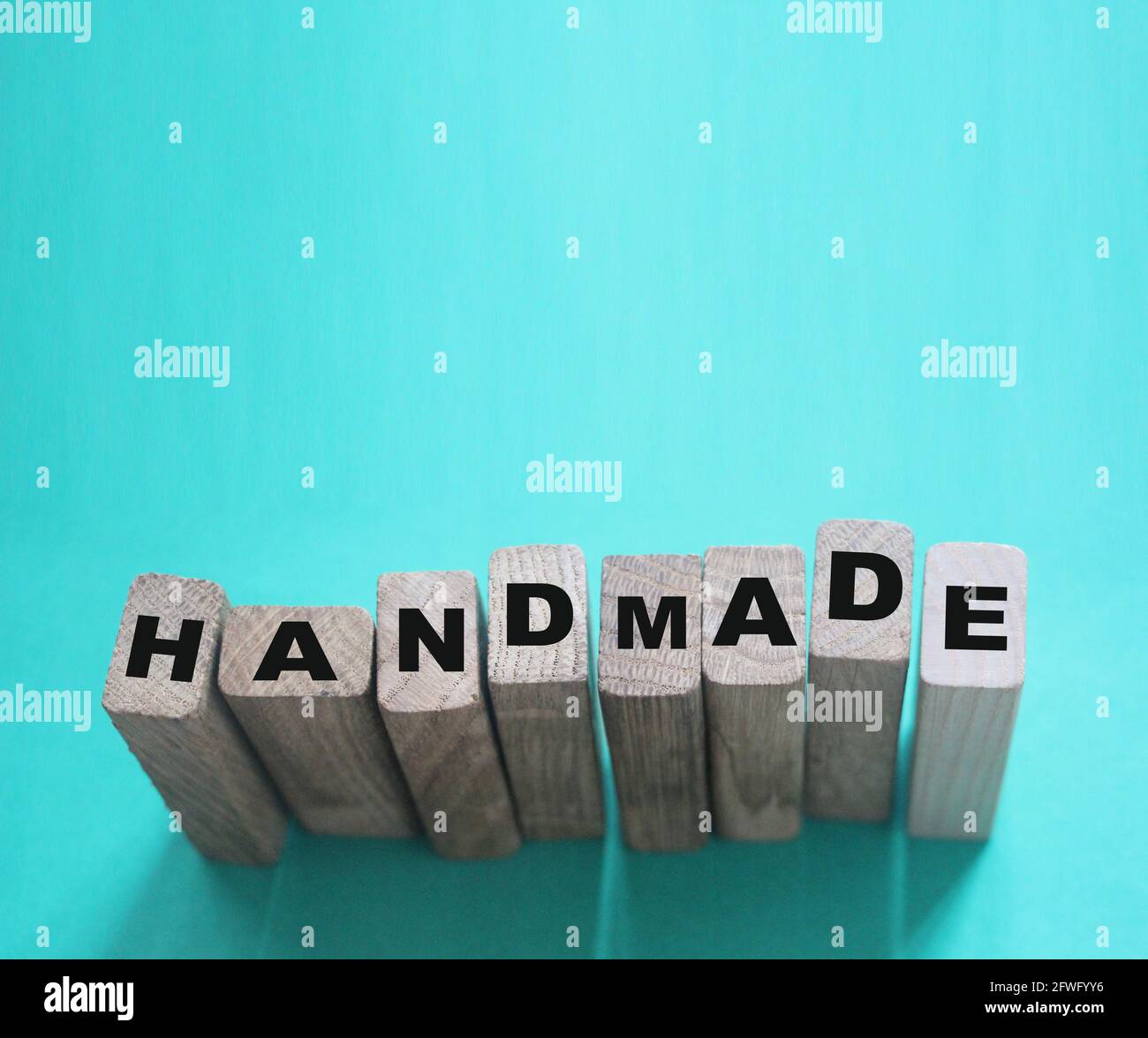 Handmade word on wooden blocks, light blue background. Hobby handmade ...