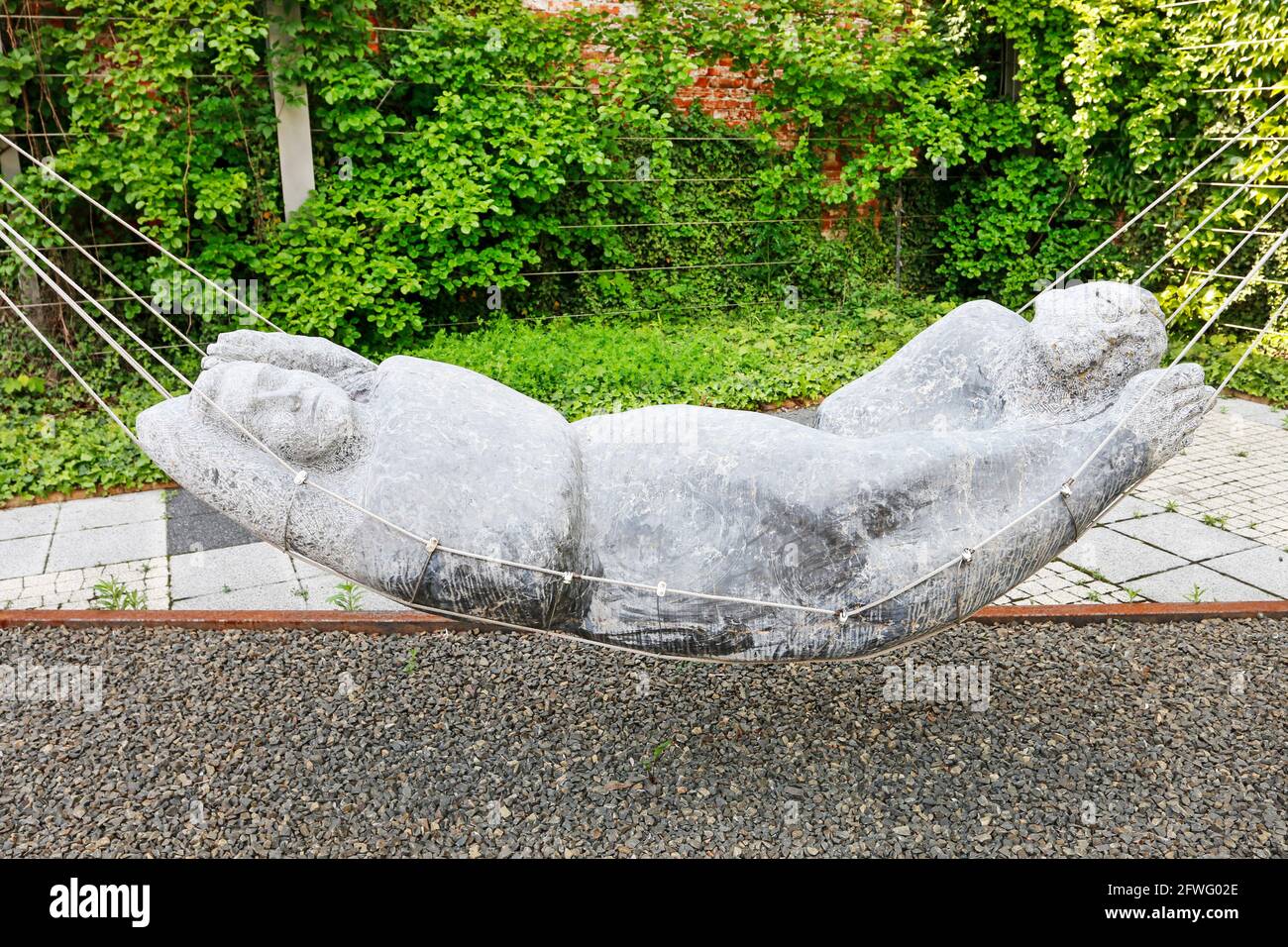 Modern sculpture of sleeping people in museum garden in Krakow, Poland ...