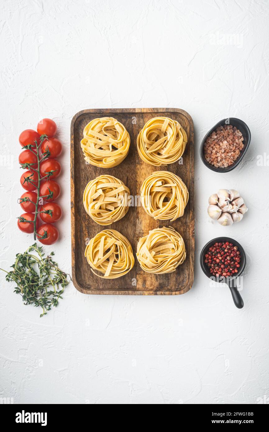 Rolled tagliatelle shape of italian pasta with ingredients set, on ...