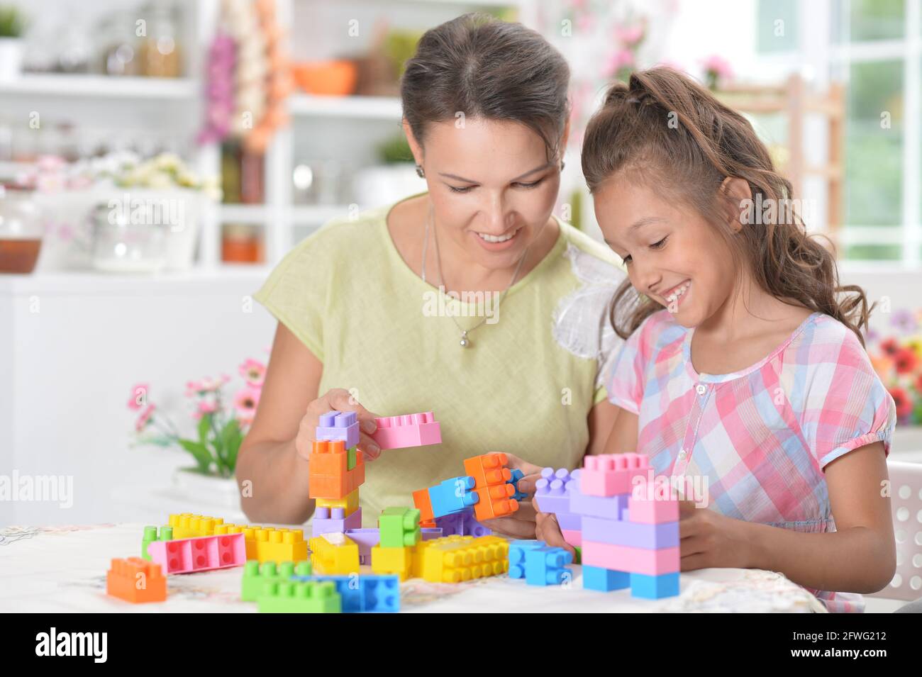 Young mother and little daughter playing lego game Stock Photo - Alamy