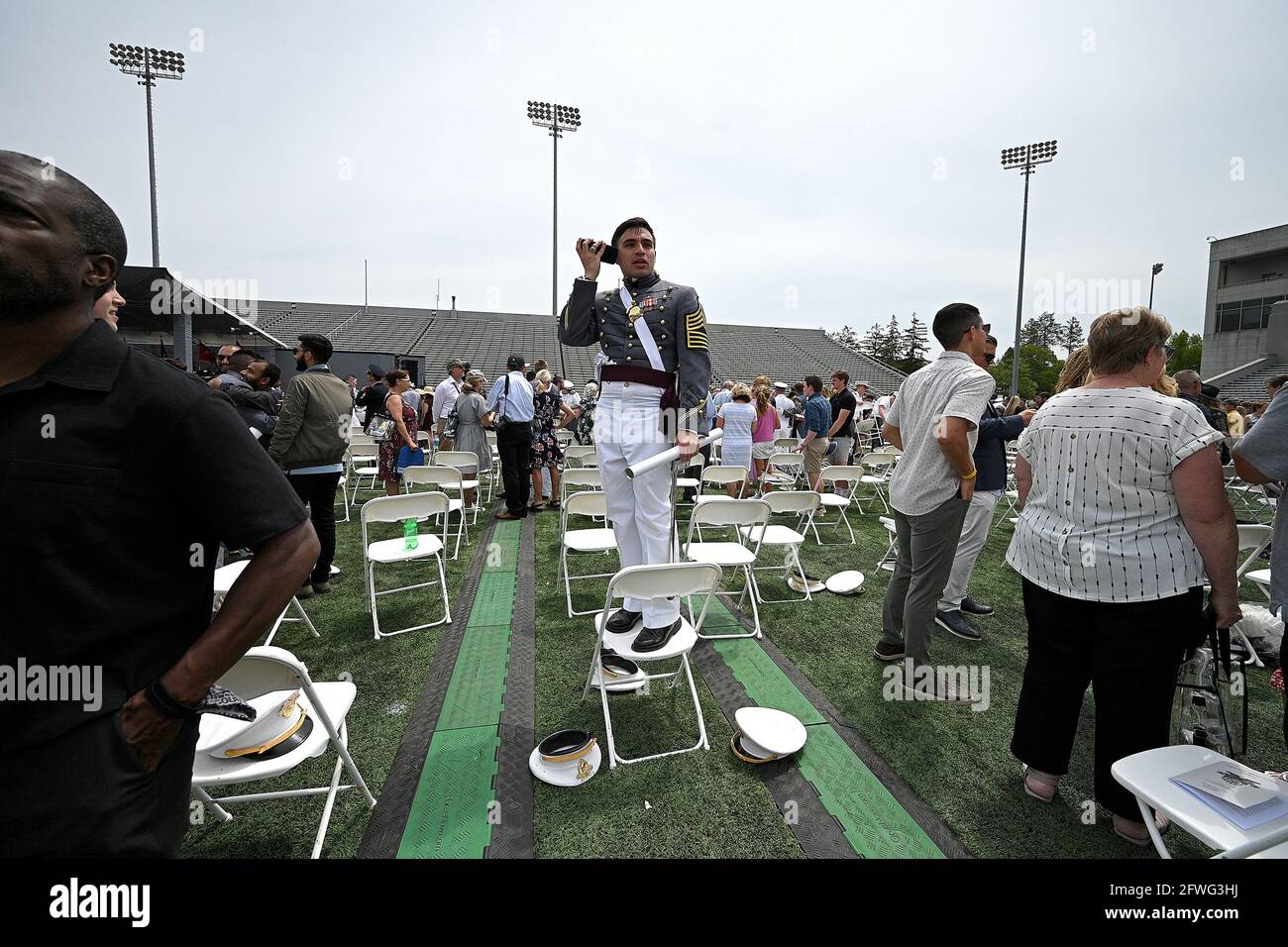 A West Point graduate stands on a chair looking for his family at the ...