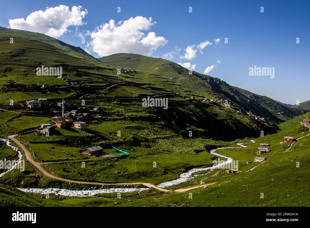 An image of houses positioned on mountains where nature gushes from the ...